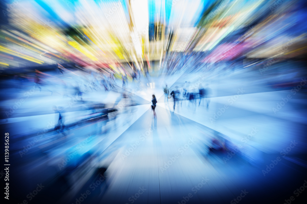 Motion and zoom blurred pedestrians crossing sunlit square. Effect made ...
