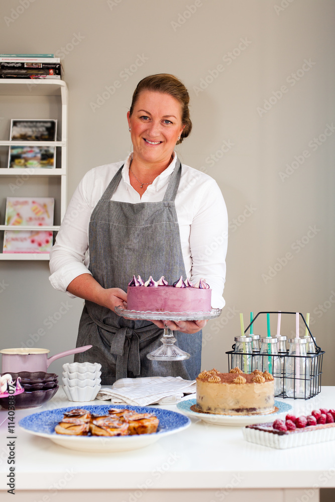 kvinna visar upp sina bakverk som hon bakat Stock Photo | Adobe Stock