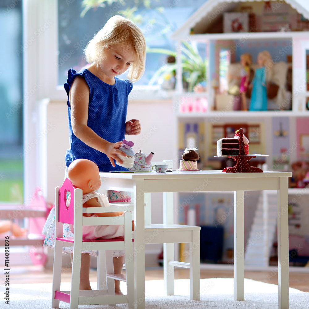 Cute preschooler girl having birthday tea party with her doll. Little ...