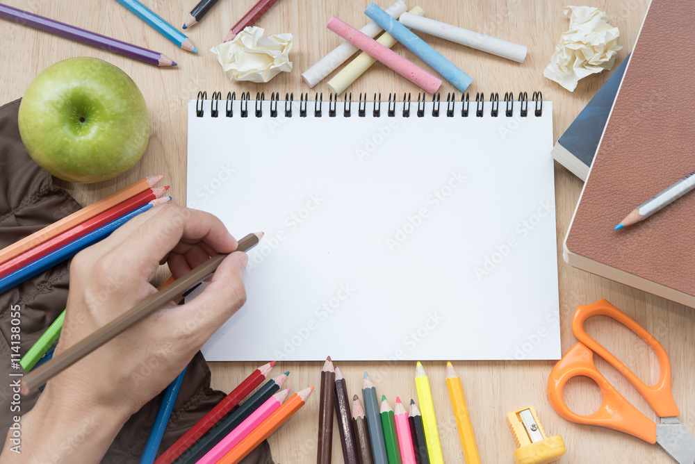 Hand holding pencil with School supplies and white paper backgro Stock ...