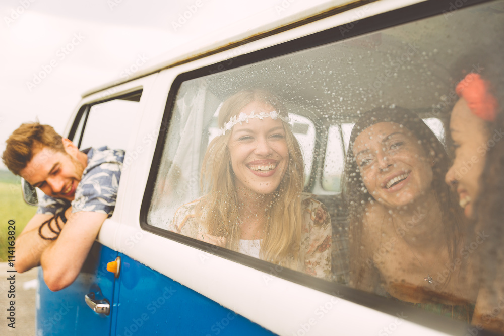 Hippie friends having fun into a vintage van, taking a break after long ...