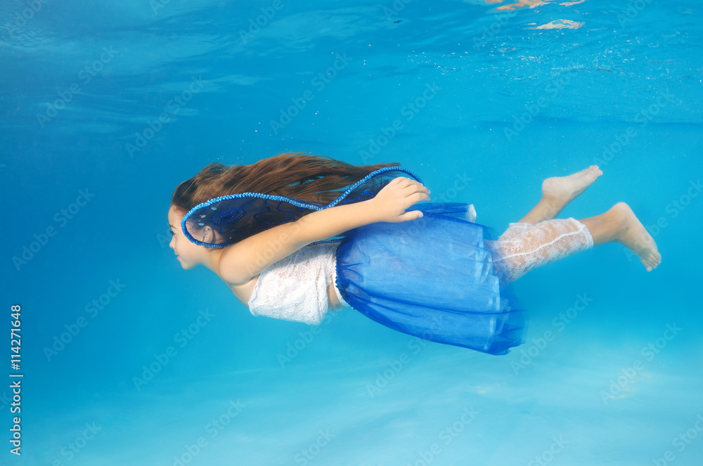 Girl presenting underwater fashion in pool Stock Photo | Adobe Stock