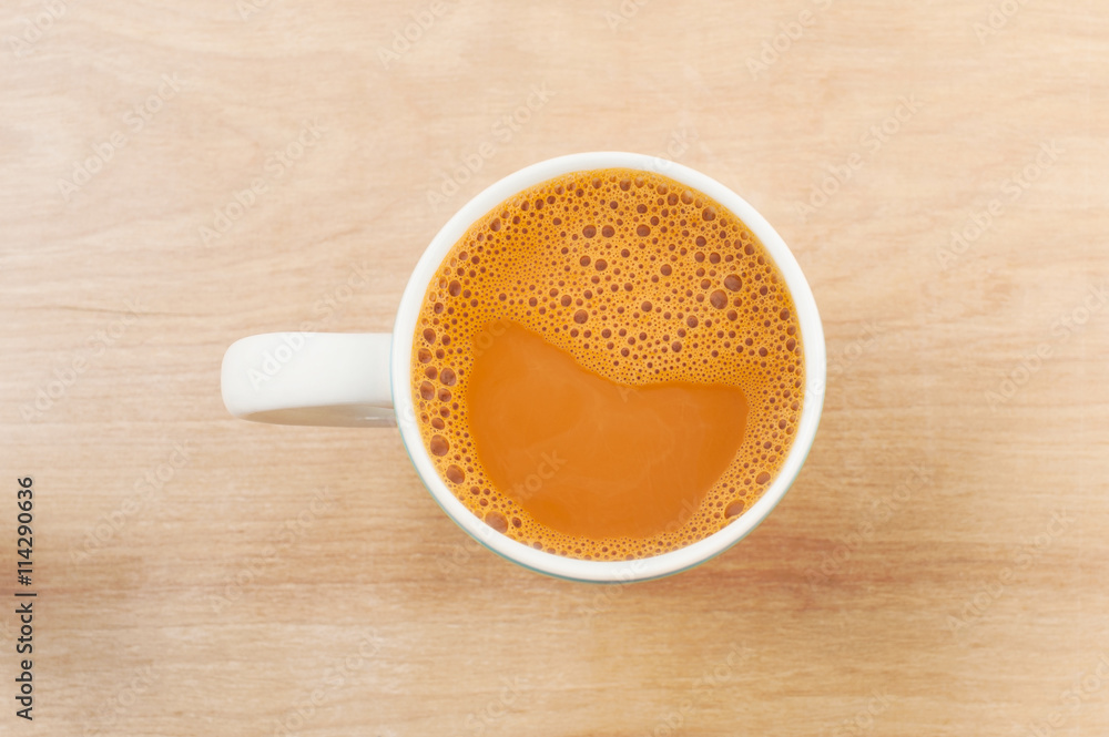Hot milk tea in a white cup on table Stock Photo | Adobe Stock