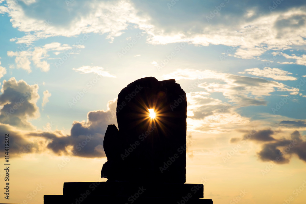 Silhouette statue with sun lens flare through the statue's hole in ...