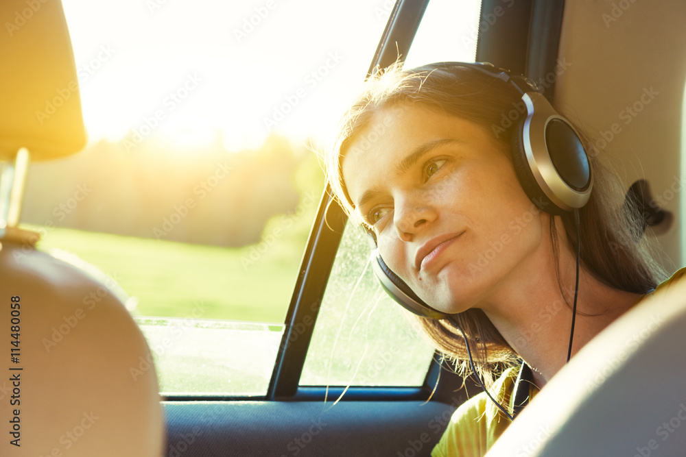 girl listening to music with headphones moving in car Stock Photo ...