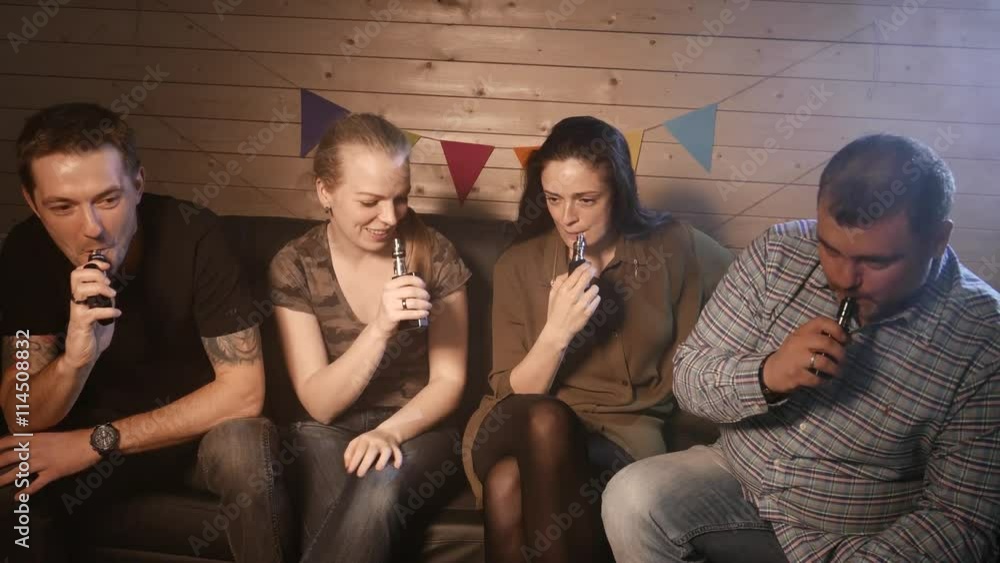 A group of people vaping, inhaling and exhaling large clouds of smoke ...