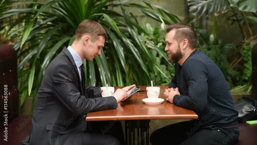 Handsome two businessmen have a meeting in cafe Stock Video | Adobe Stock