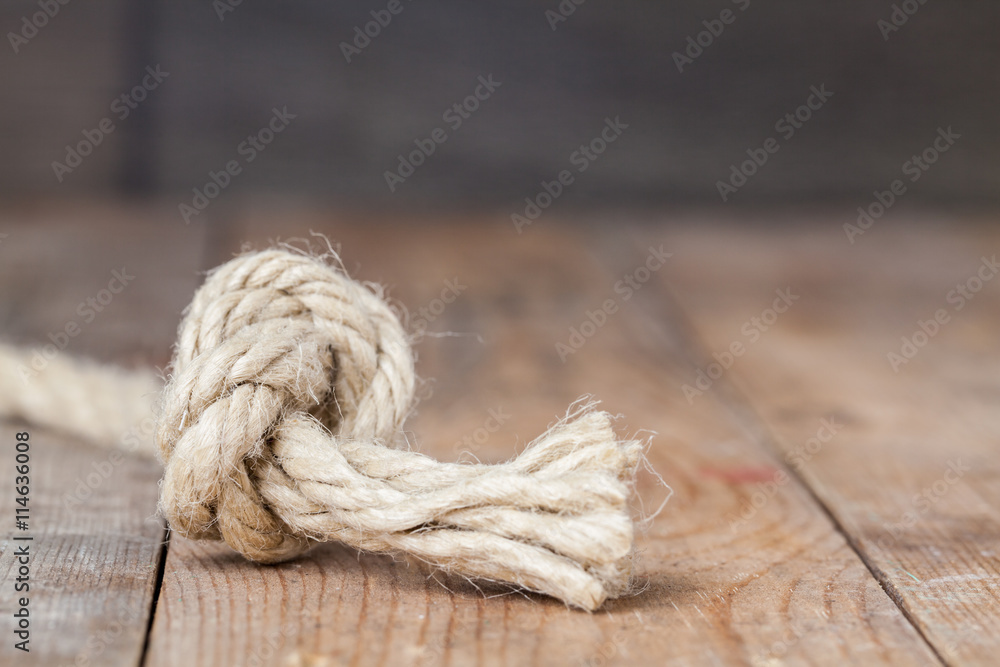 Old frayed rope twisted and tied in a bundle on a rough wooden ...