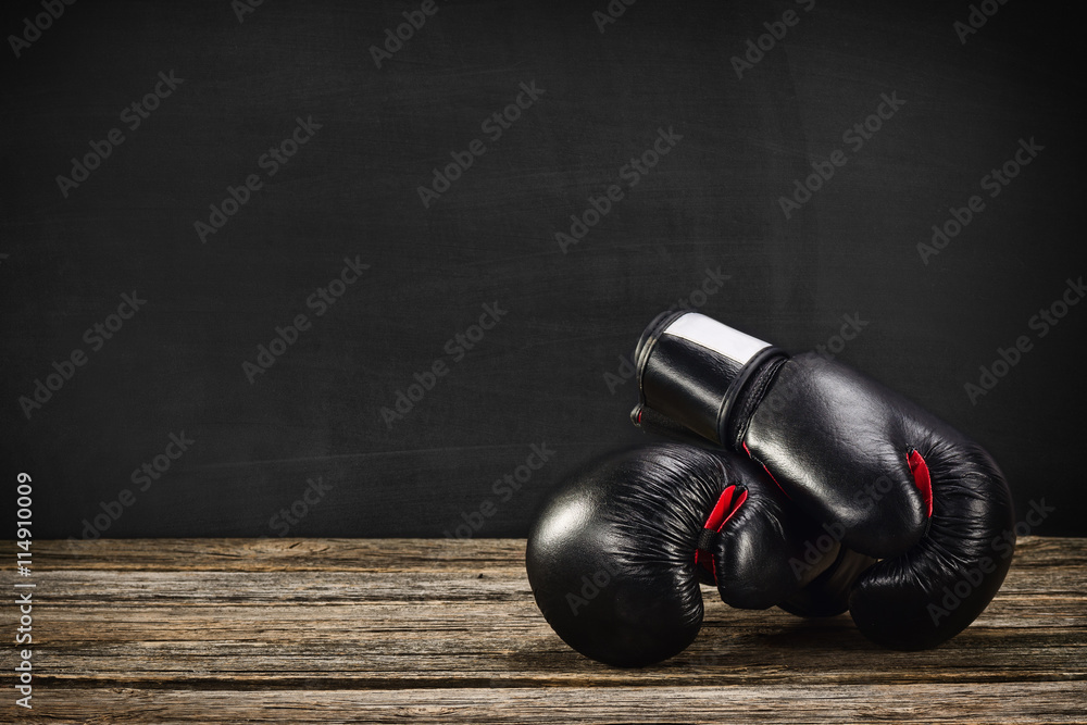 Pair of boxing gloves on a vintage wooden desk with chalkboard ...