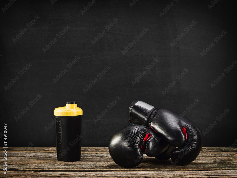 Pair of boxing gloves on a vintage wooden desk with chalkboard ...