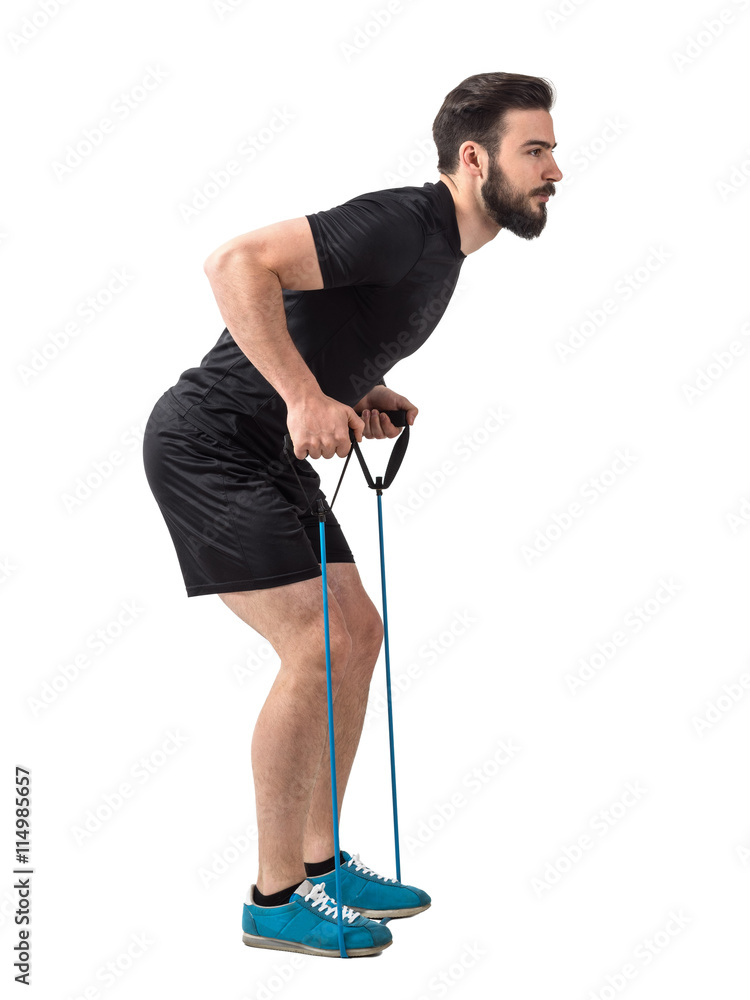 Side view of young fit athlete with resistance bands doing back ...