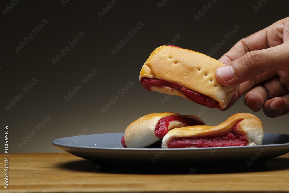 Hand getting a freshly baked Filipino sweet bread called "pan-de-regla ...