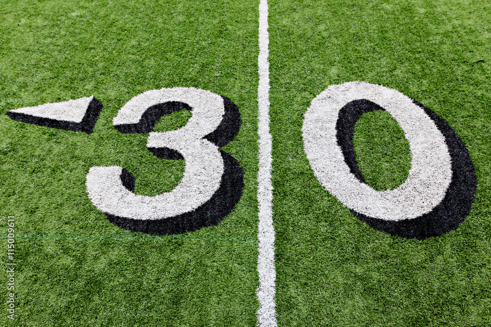 30 yard line on a green football field with white lettering Stock Photo ...