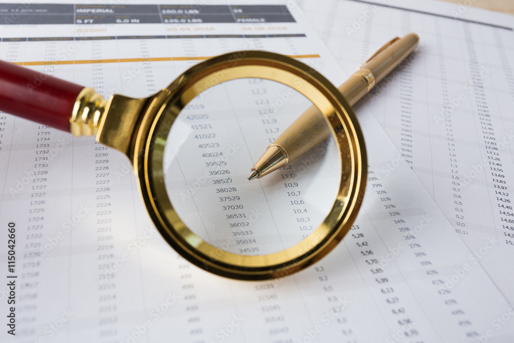 Looking through magnifying glass to financial report Stock Photo ...