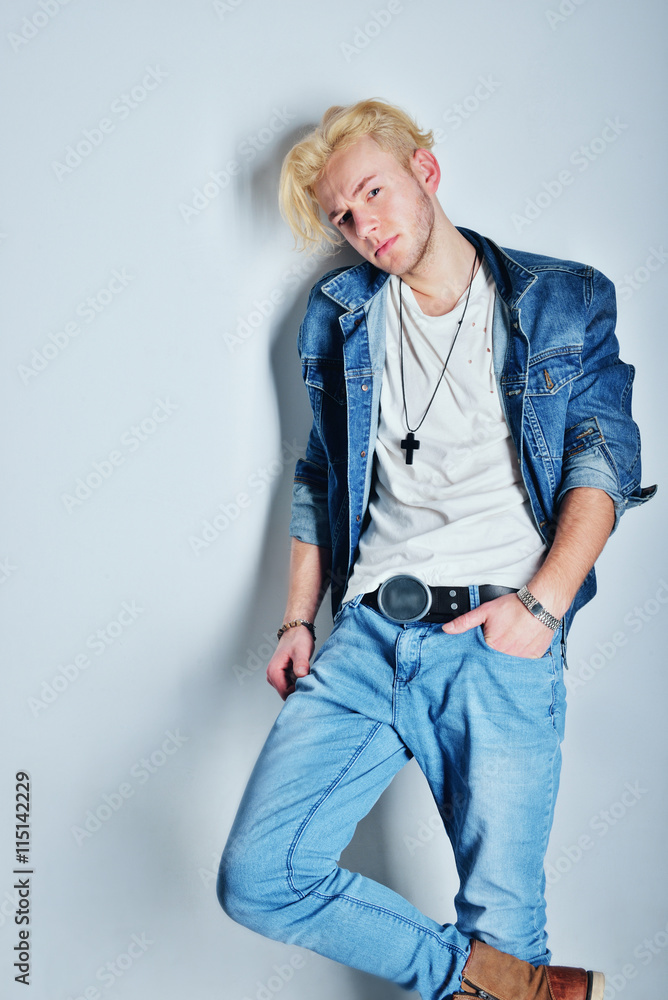 Handsome young fashion male model posing with jacket over his shoulder ...