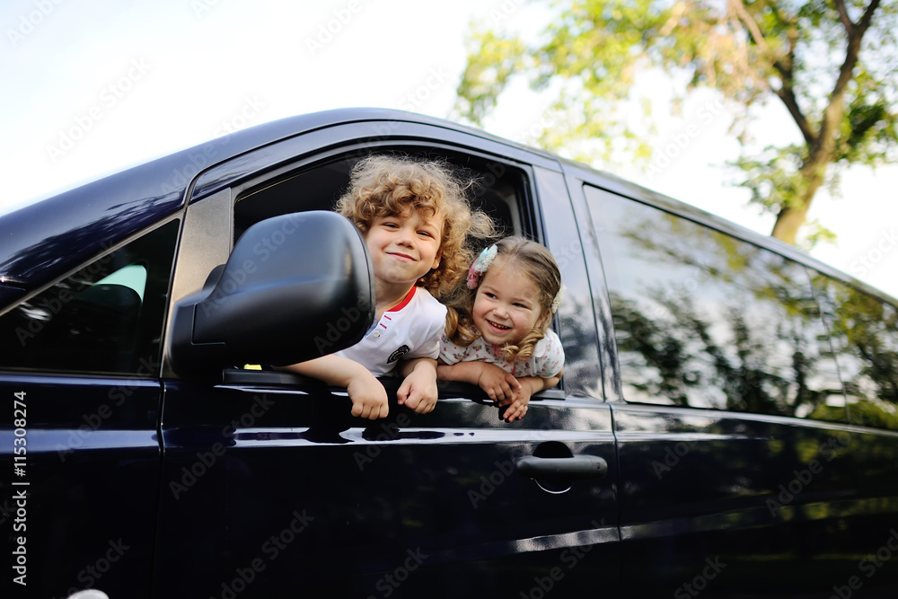 children look out from a car window.little boy and girl playing inside ...