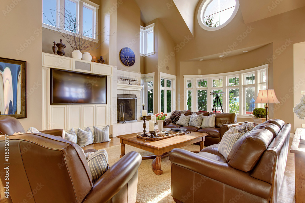 Large living room interior design with high vaulted ceiling and leather ...