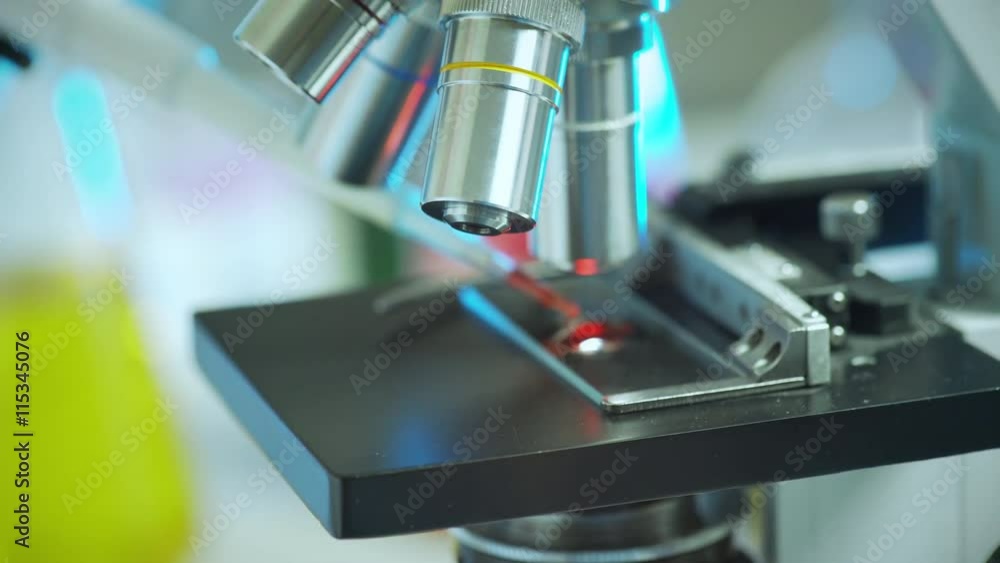 A specimen on a microscope slide being placed and adjusted on the ...