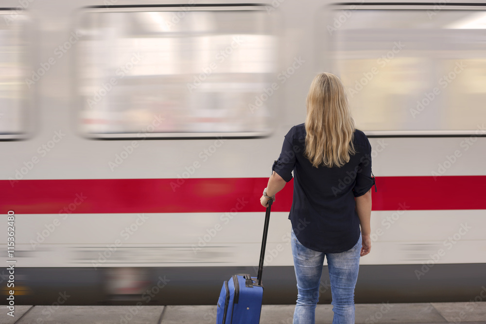Woman at train station with incoming train Stock Photo | Adobe Stock