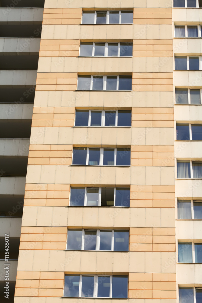 High rise building facade, eight floors, dark yellow wall and windows ...