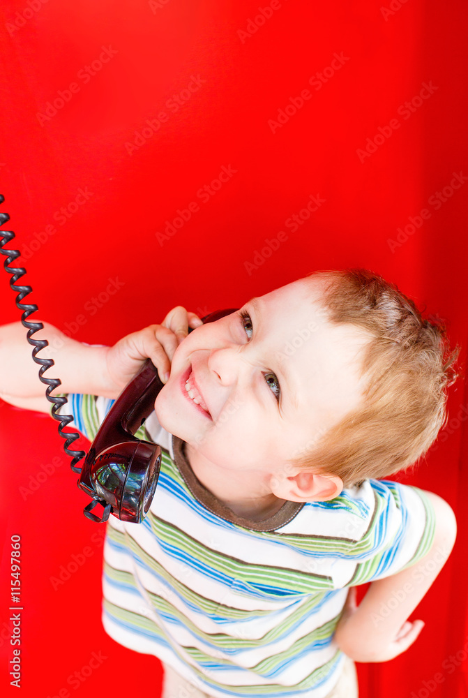 funny kid talking on the phone in telephone box. concept of sharing ...