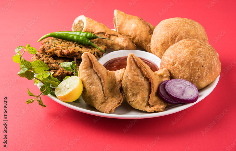 coriander vada or kothimbir vada, samosa, kachori, daal vada on brown ...