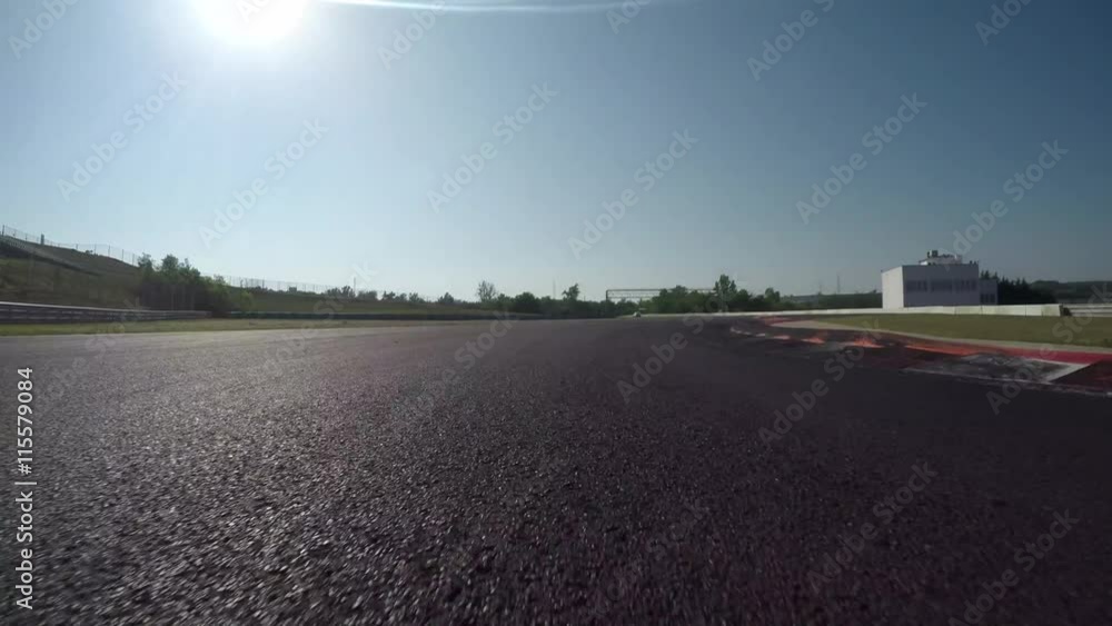 LOW ANGLE VIEW: Race car competing and driving fast on race track lap ...
