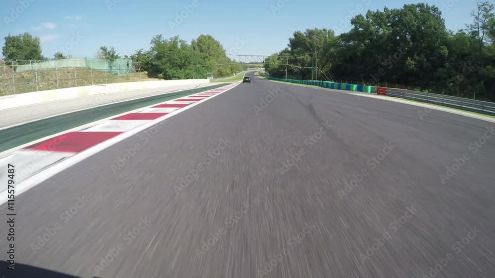 LOW ANGLE VIEW: Race car competing and driving fast on race track lap ...