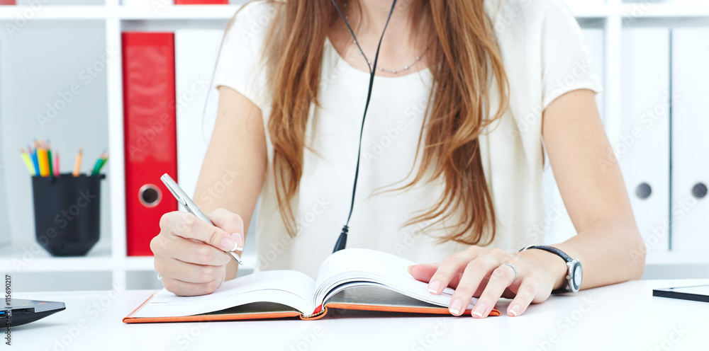 Busy secretary is answering call by handset and writing memo at the ...