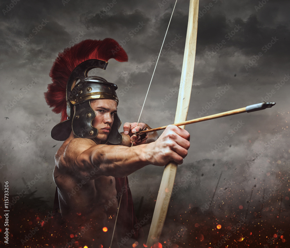 Muscular male in spartan costume holding wooden bow. Stock Photo ...