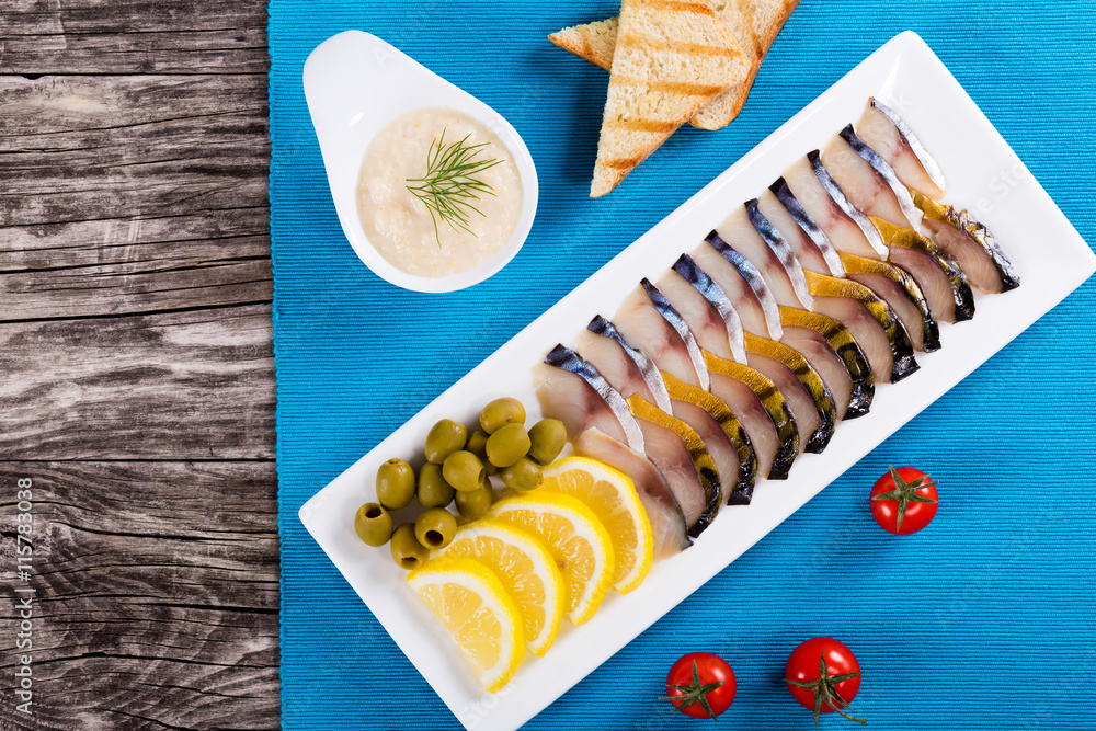 fish appetizer with sliced lemon, green olives and tomatoes Stock-Foto ...