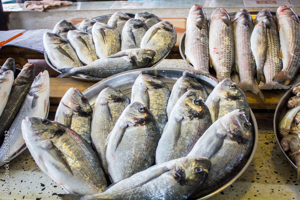 fresh fish in different sizes laying on a table Stock Photo | Adobe Stock