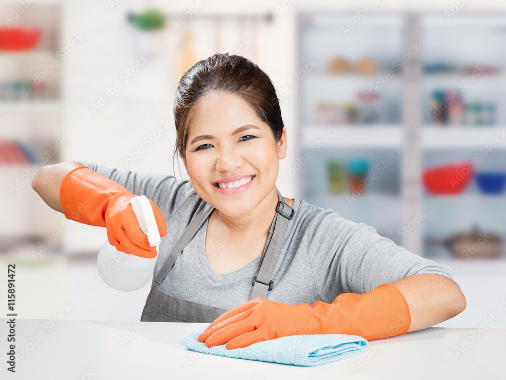asian housewife holding spray bottle and rag with kitchen background ...
