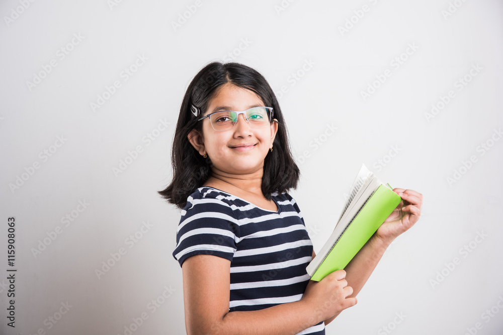 Cute and studious little Indian/asian girl studying/reading book while ...