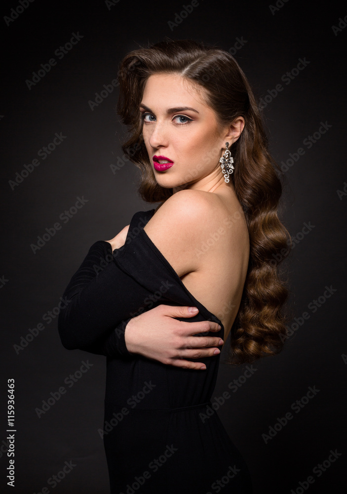 Portrait of beautiful model lady in black dress posing in studio ...