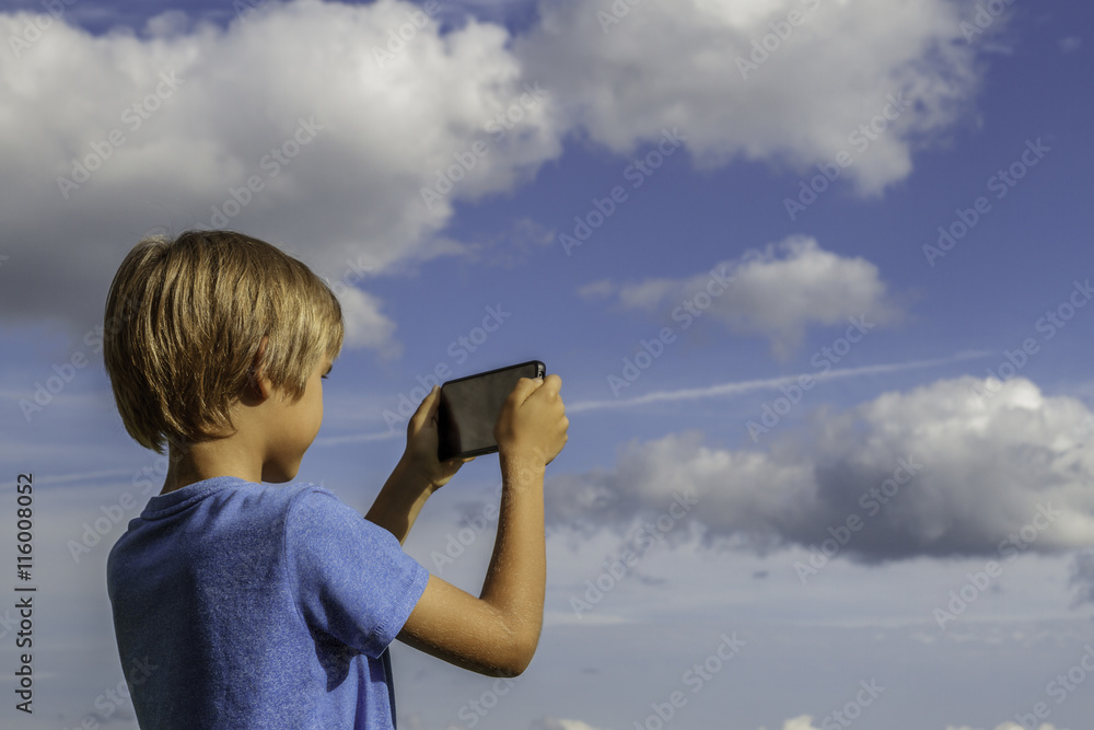 Boy using mobile phone. Child taking photo with his smartphone ...