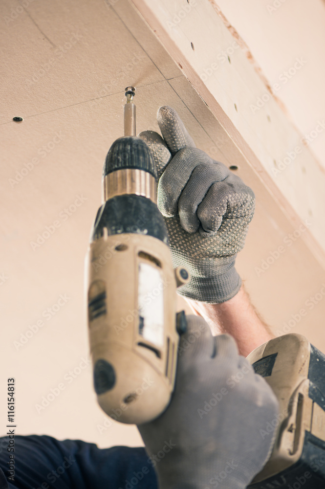 man working with screwdriver on gypsum plasterboard at ceiling Stock ...