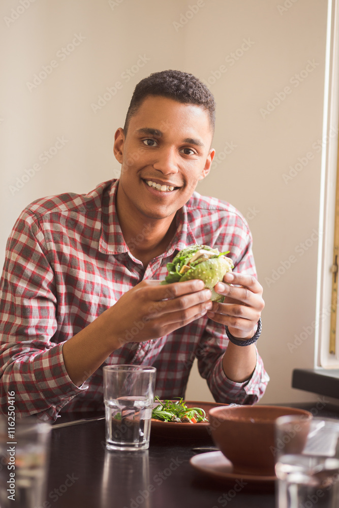 Picture of happy man eating vegan burger in vegan restaurant or cafe ...