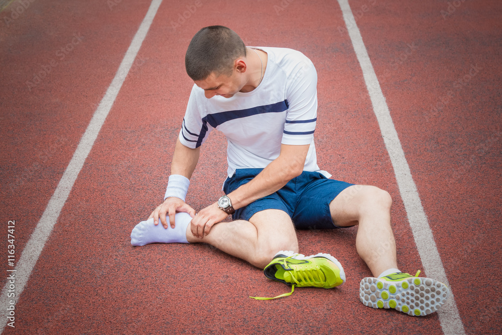 Jogger hands on foot. He is feeling pain as his ankle or foot is broken ...