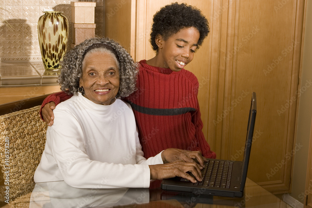 Grandson showing his grandmother how to use the computer. Stock Photo ...