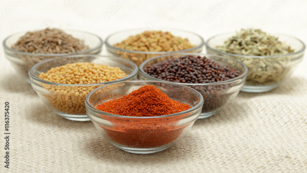 Different types of Indian spices in glass bowl, focus on red chili ...
