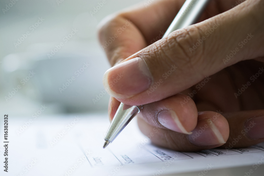 hand with pen over checklist form Stock Photo | Adobe Stock