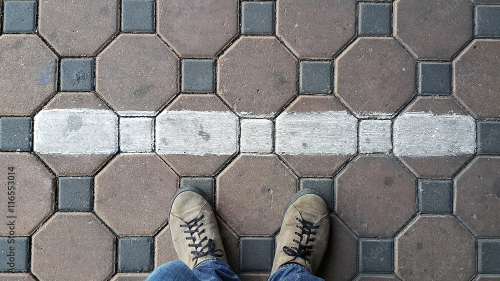 Standing inside the white lines on the ground. Stock Photo | Adobe Stock