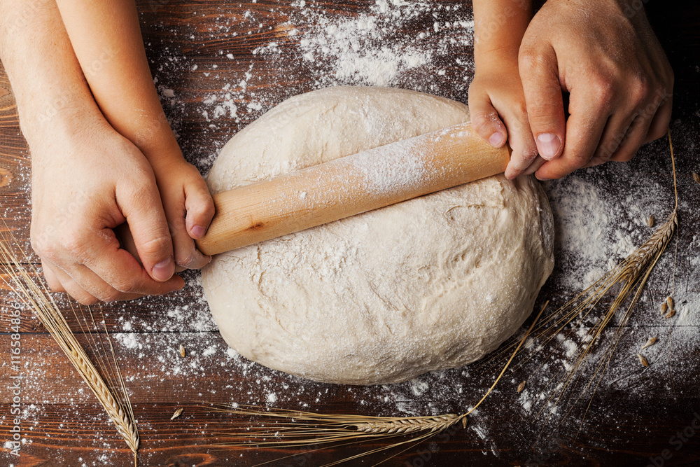 Father and child hands making the dough with flour, rolling pin and ...