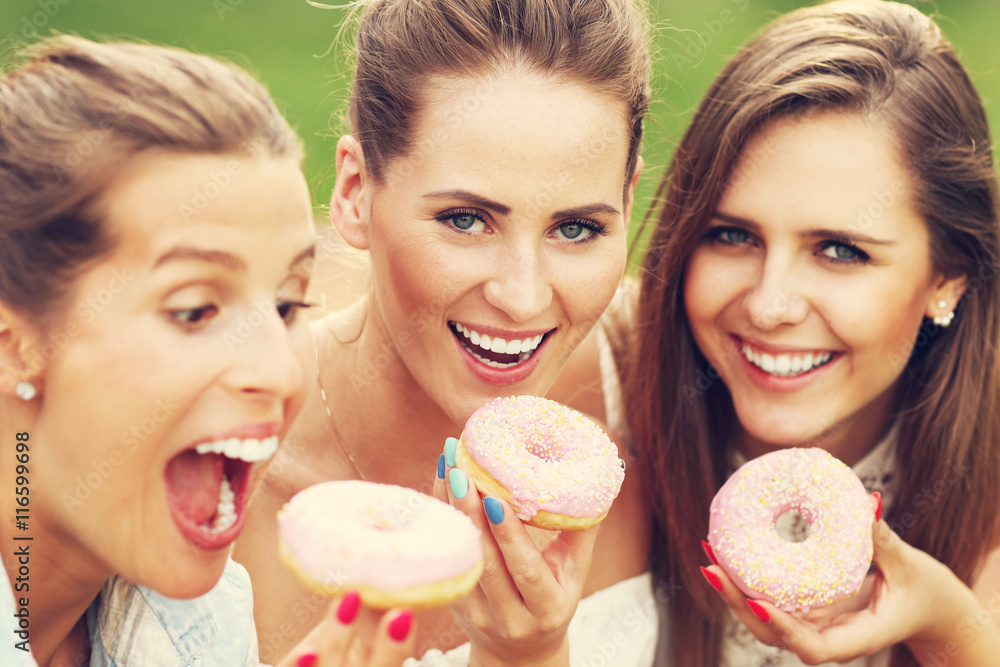 Happy group of friends eating donuts outdoors Stock Photo | Adobe Stock