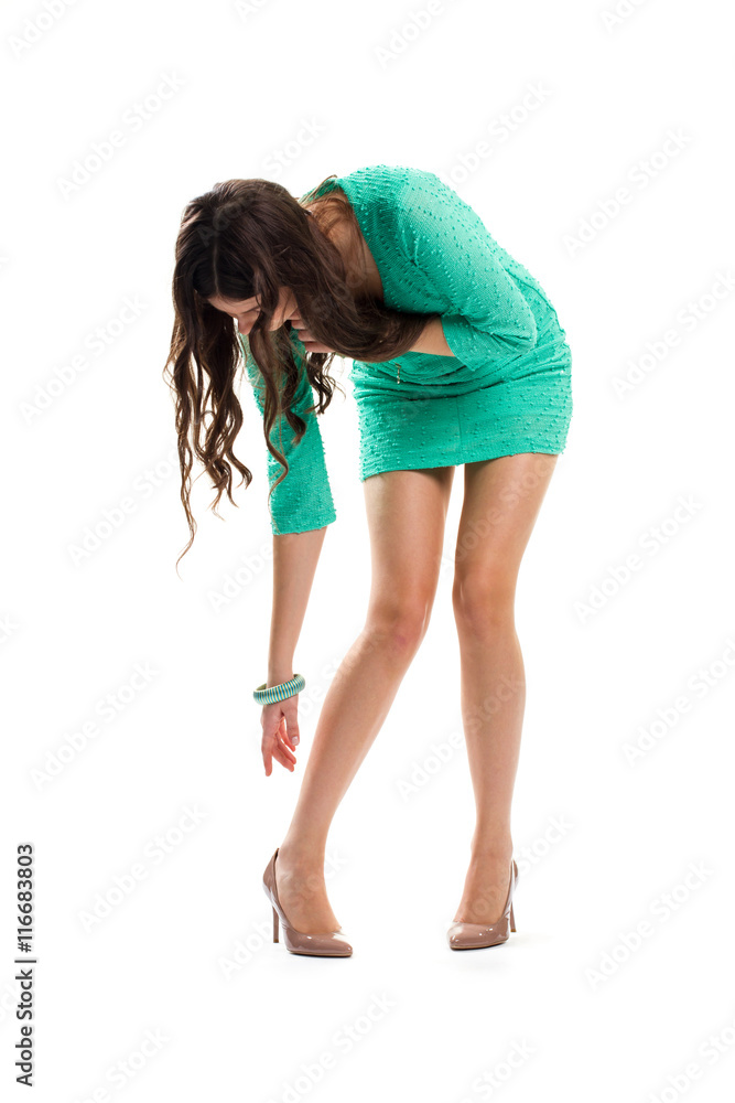 Lady in dress bends down. Short dress and heel shoes. Model wears ...