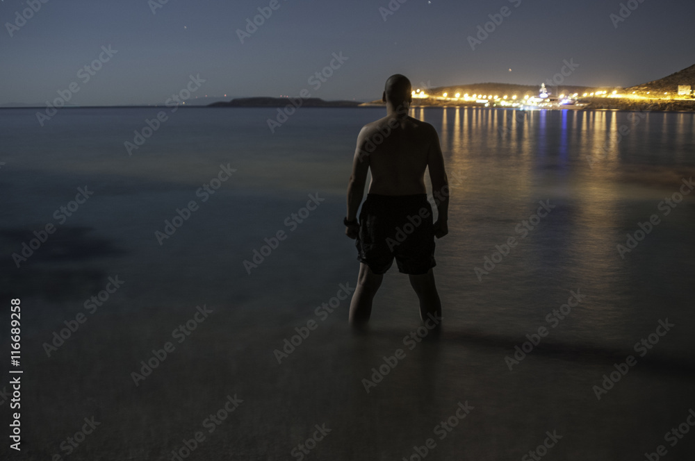 Man in sea watching the view at night Stock-Foto | Adobe Stock