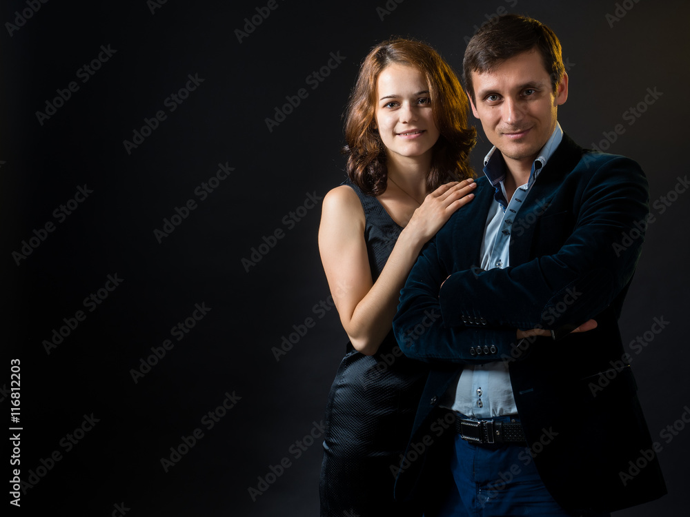 The girl in black skin-tight dress hugging a guy in velvet jacket Stock ...