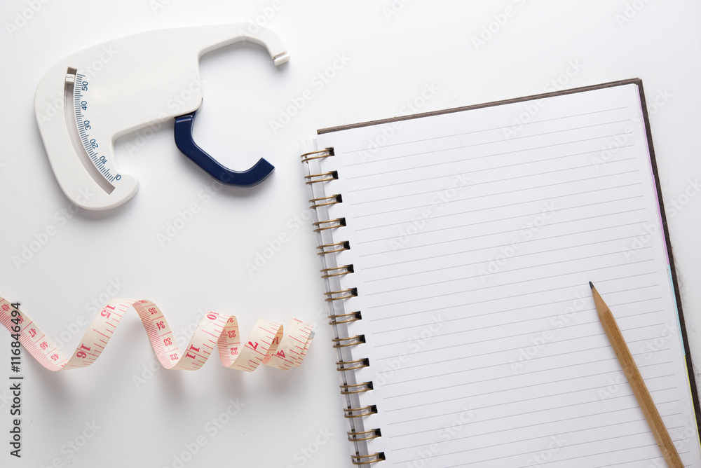 Body fat measuring calipers, measure meter and notebook white ...