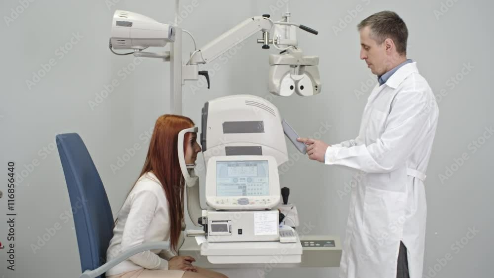 Optometrist using modern automatic refractometer to measure eye ...